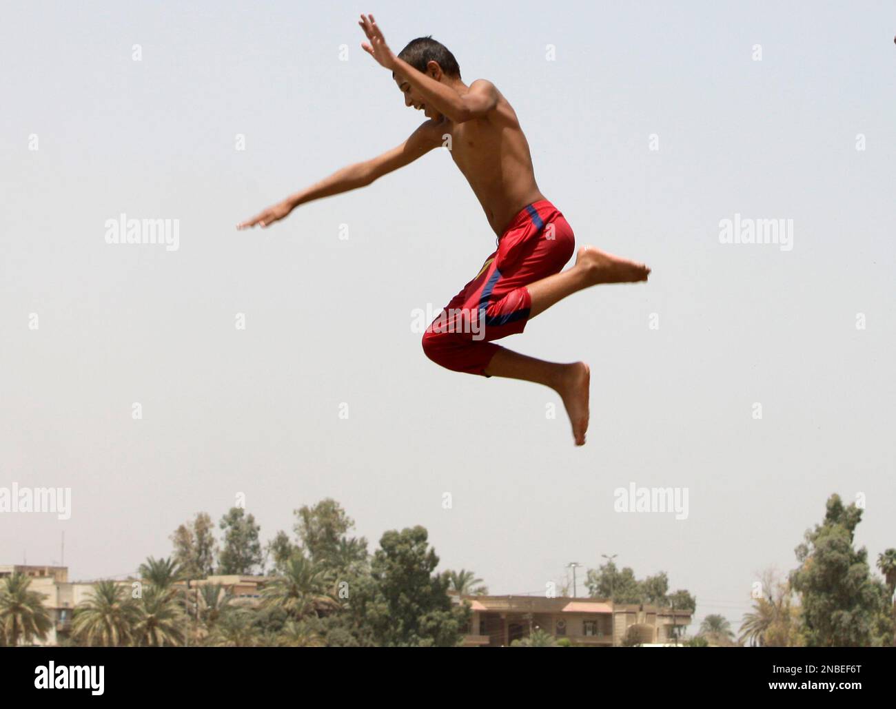 Mohammed Hadi, 15, leaps into the Tigris river to escape the summer ...