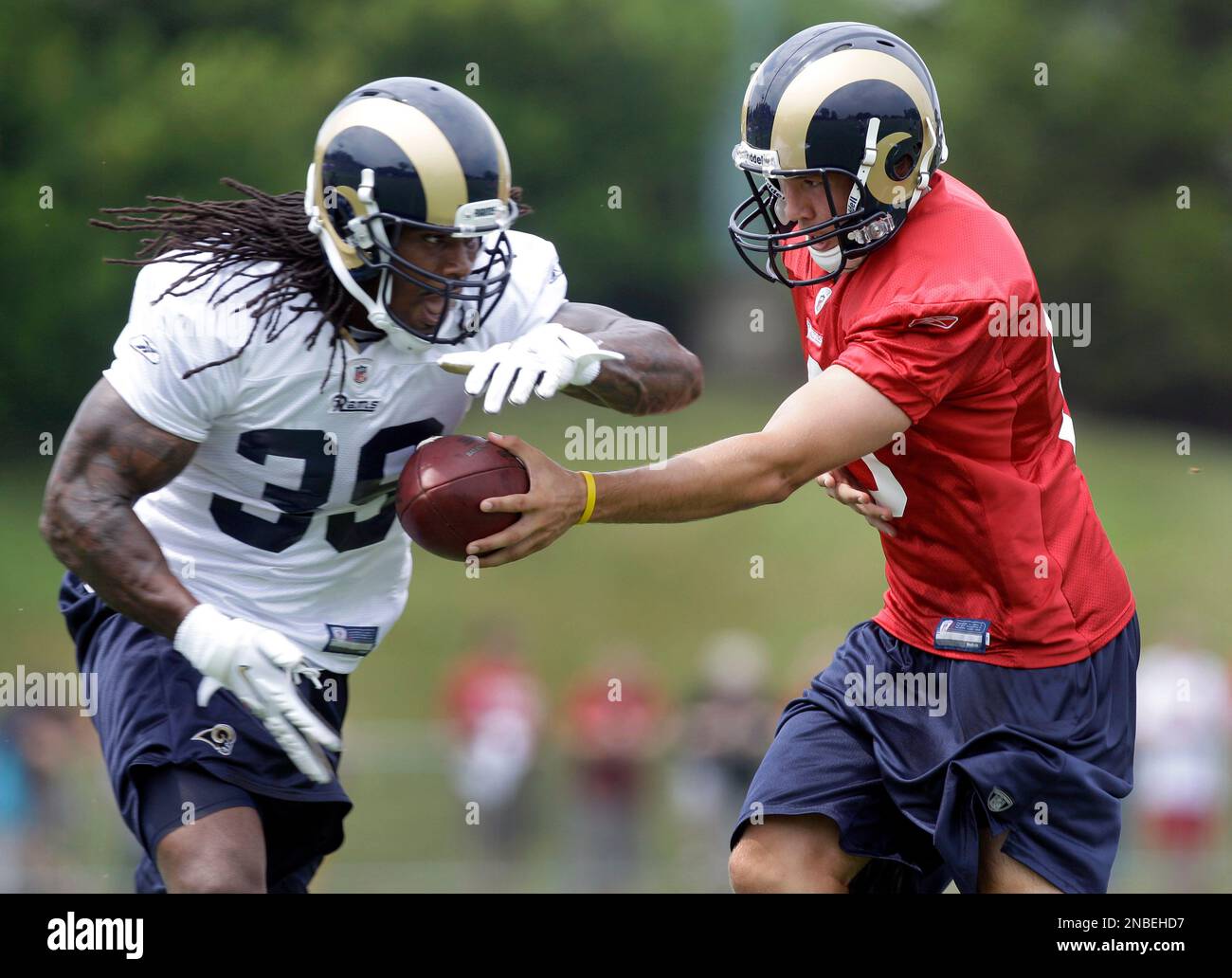 St. Louis Rams quarterback Sam Bradford, right, hands off the ball to ...