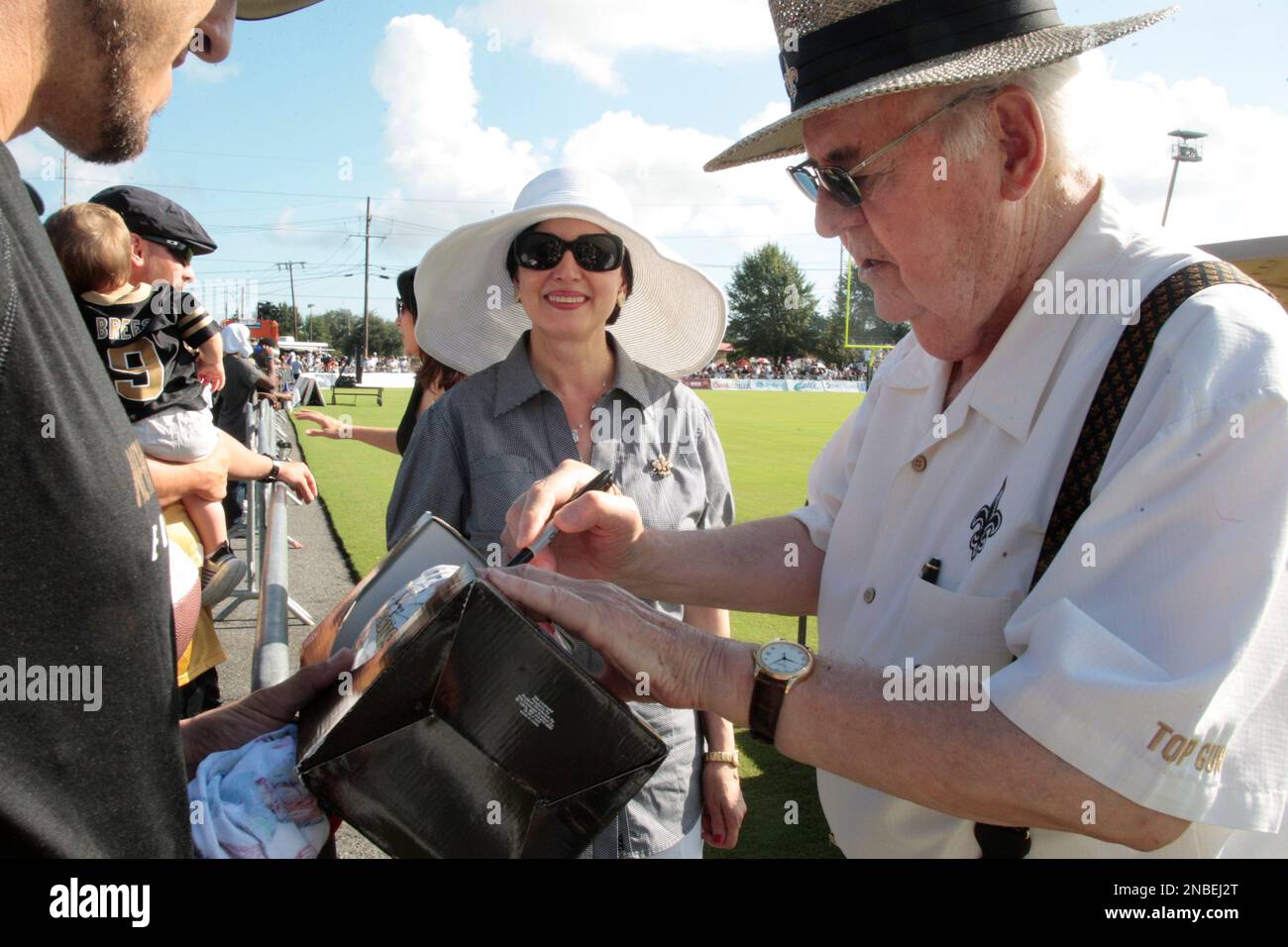 New Orleans Saints owner Tom Benson, right, signs an autograph as his ...