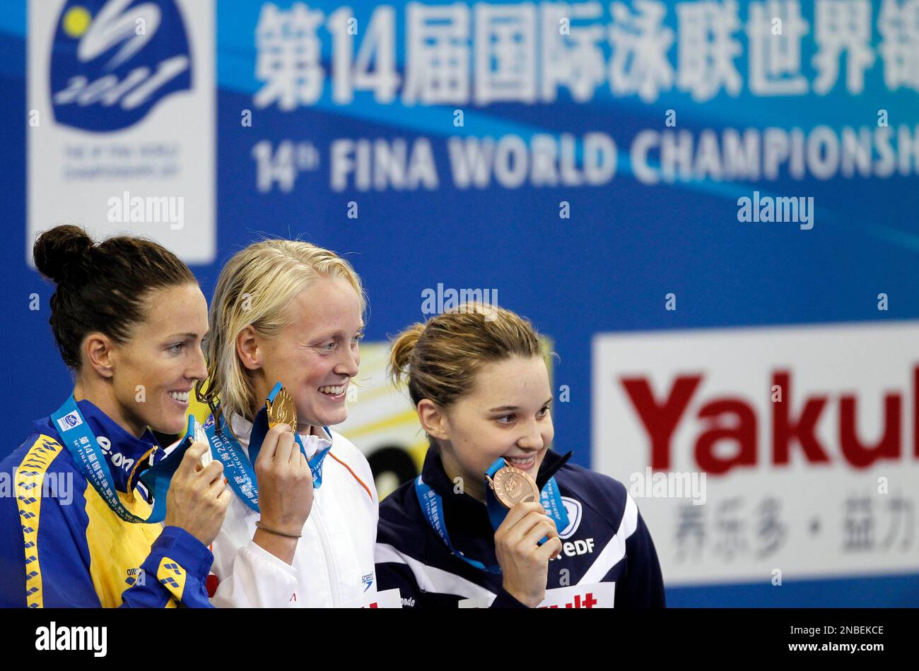 Inge Dekker, center, of the Netherlands shows her gold medal with ...