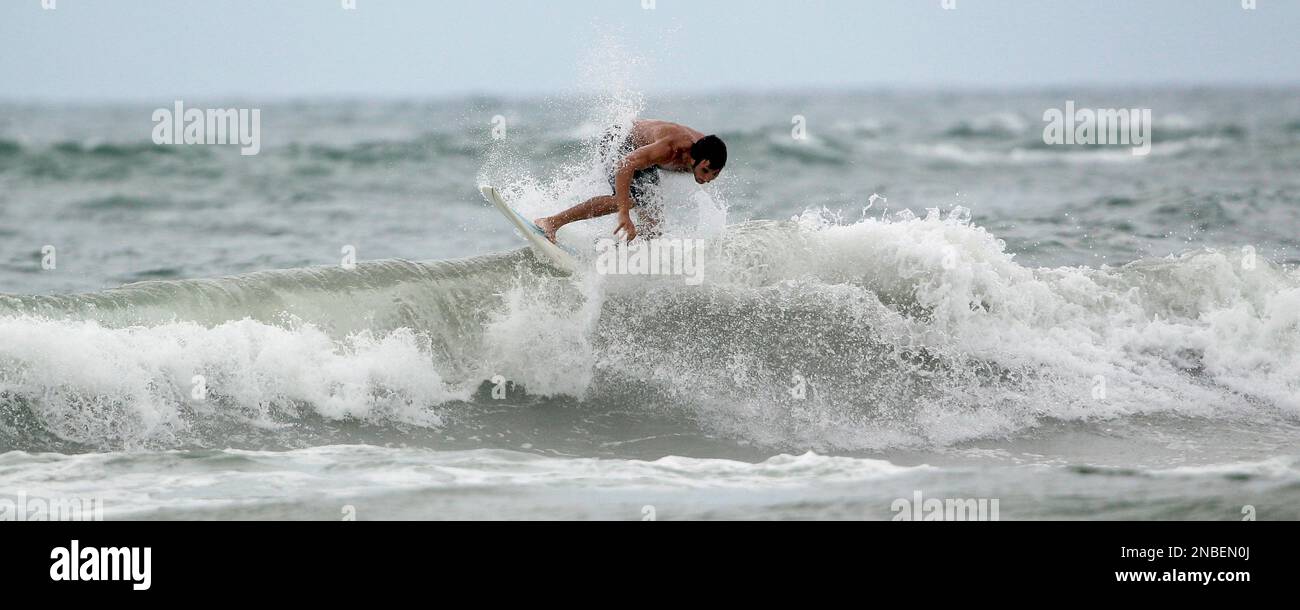 Collin Roche rides a wave as he surf in the Gulf of Mexico as Tropical ...