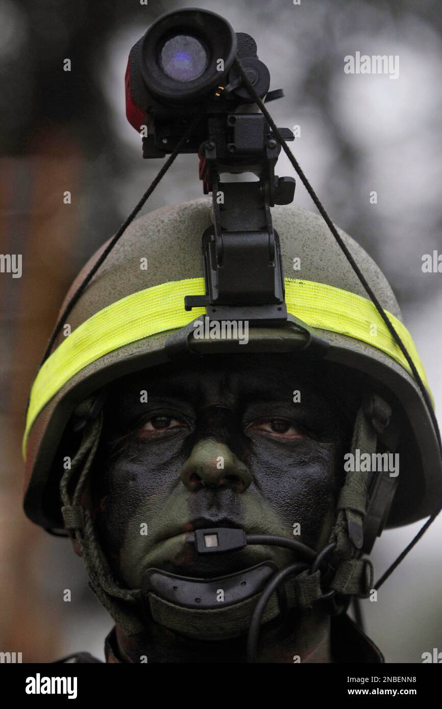 A soldier wears a helmet with a infrared cam on top during a military ...
