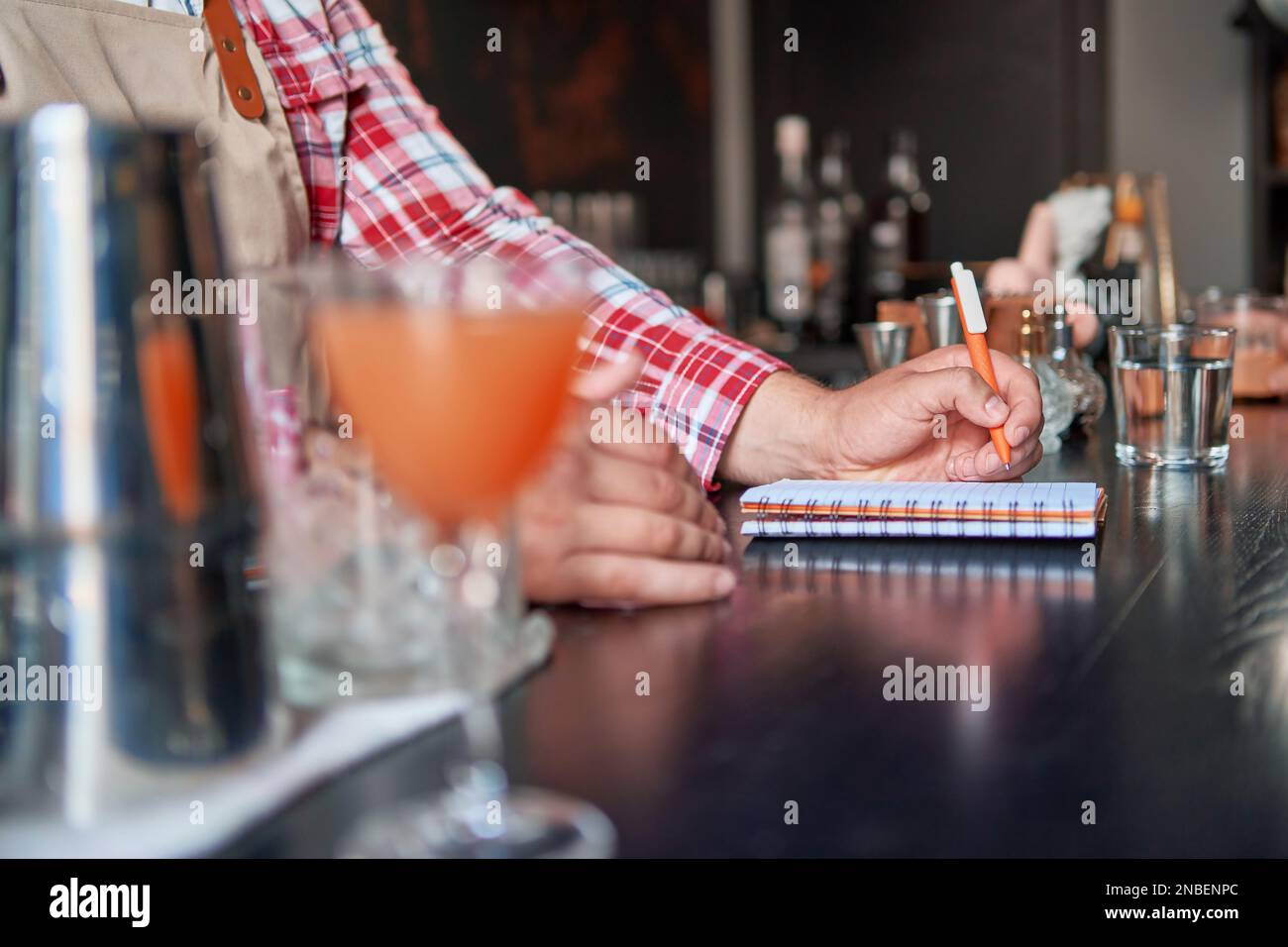 bartender standing at bar counter taking notes Stock Photo - Alamy