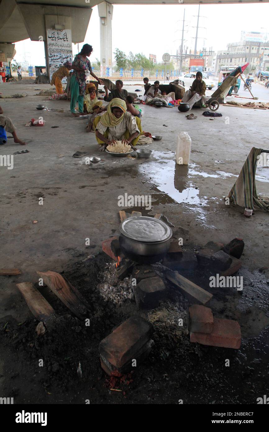 Pakistani homeless families who live under a bridge, prepare food in ...