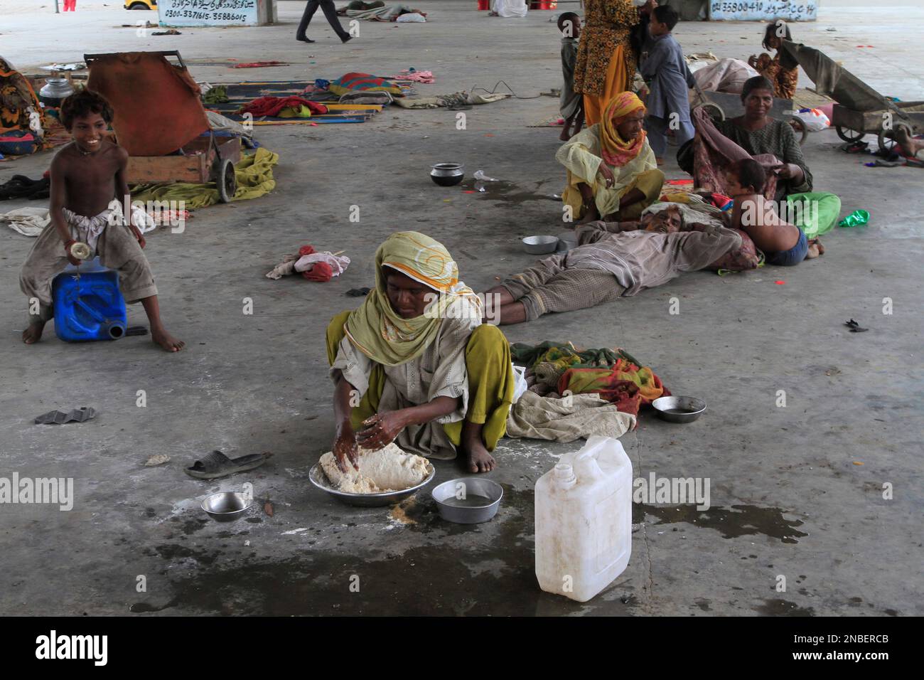 Pakistani homeless families living under a bridge, prepare food in ...