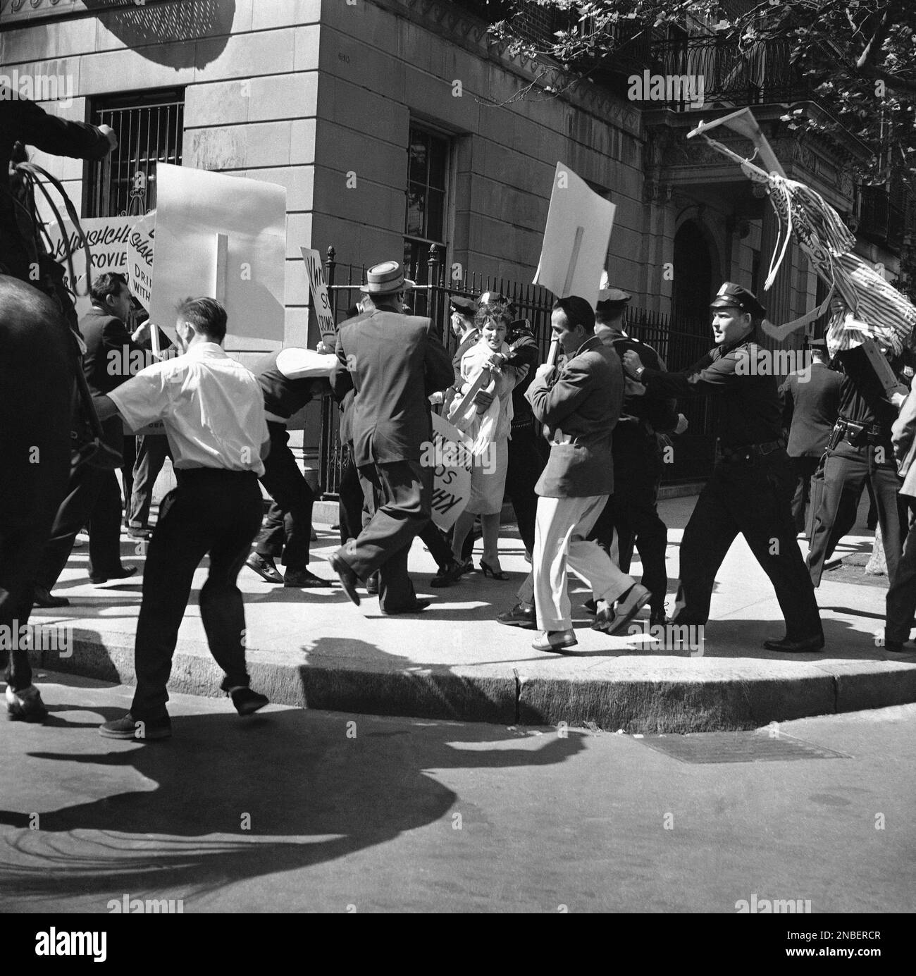 Plain clothes police officer, wearing hat and suit in center, and ...