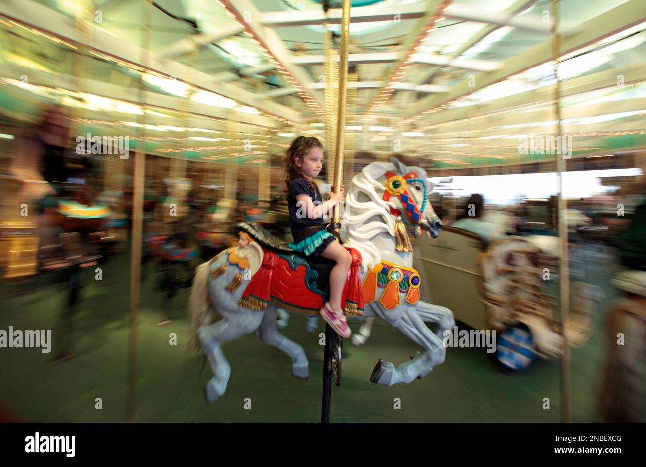 In this photo taken Wednesday, June 29, 2011, a girl rides the Looff ...