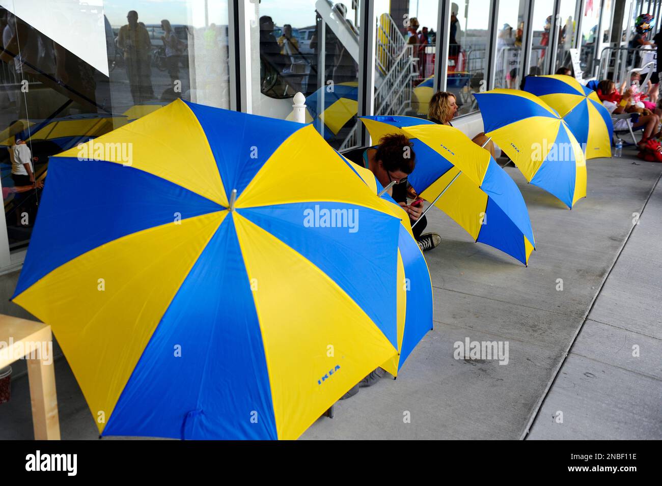 Customers wait in line under umbrellas at the IKEA grand opening in the ...