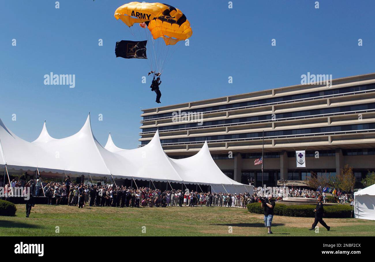 A member of the U.S. Army Golden Knights parachutes onto the front lawn ...