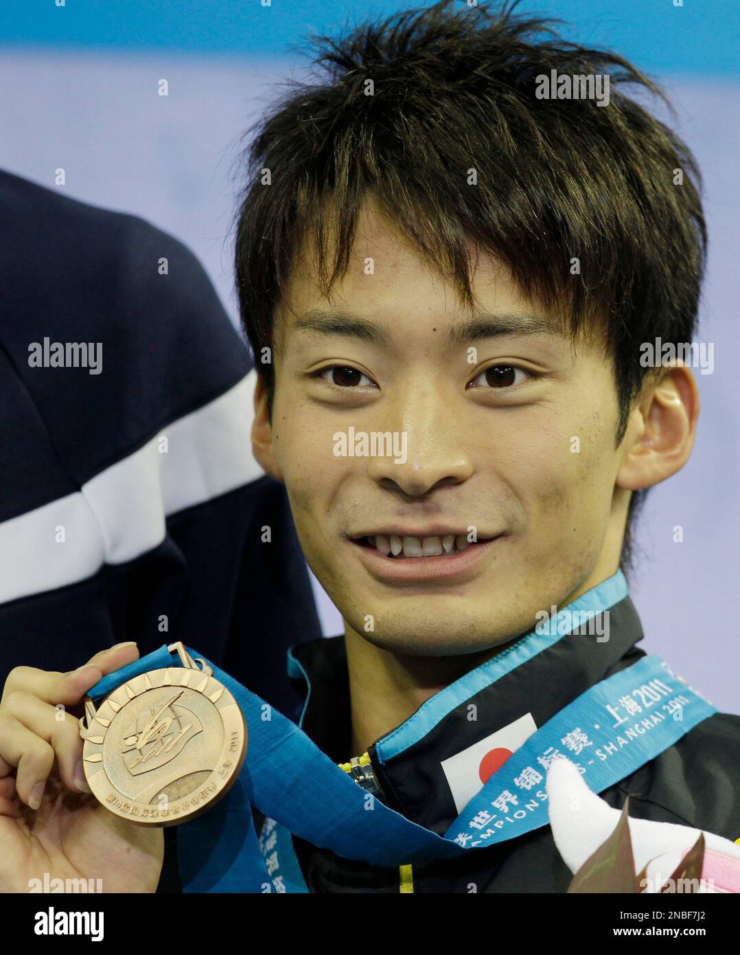 Japan's Ryosuke Irie holds up his bronze medal for the men's 100 meters ...