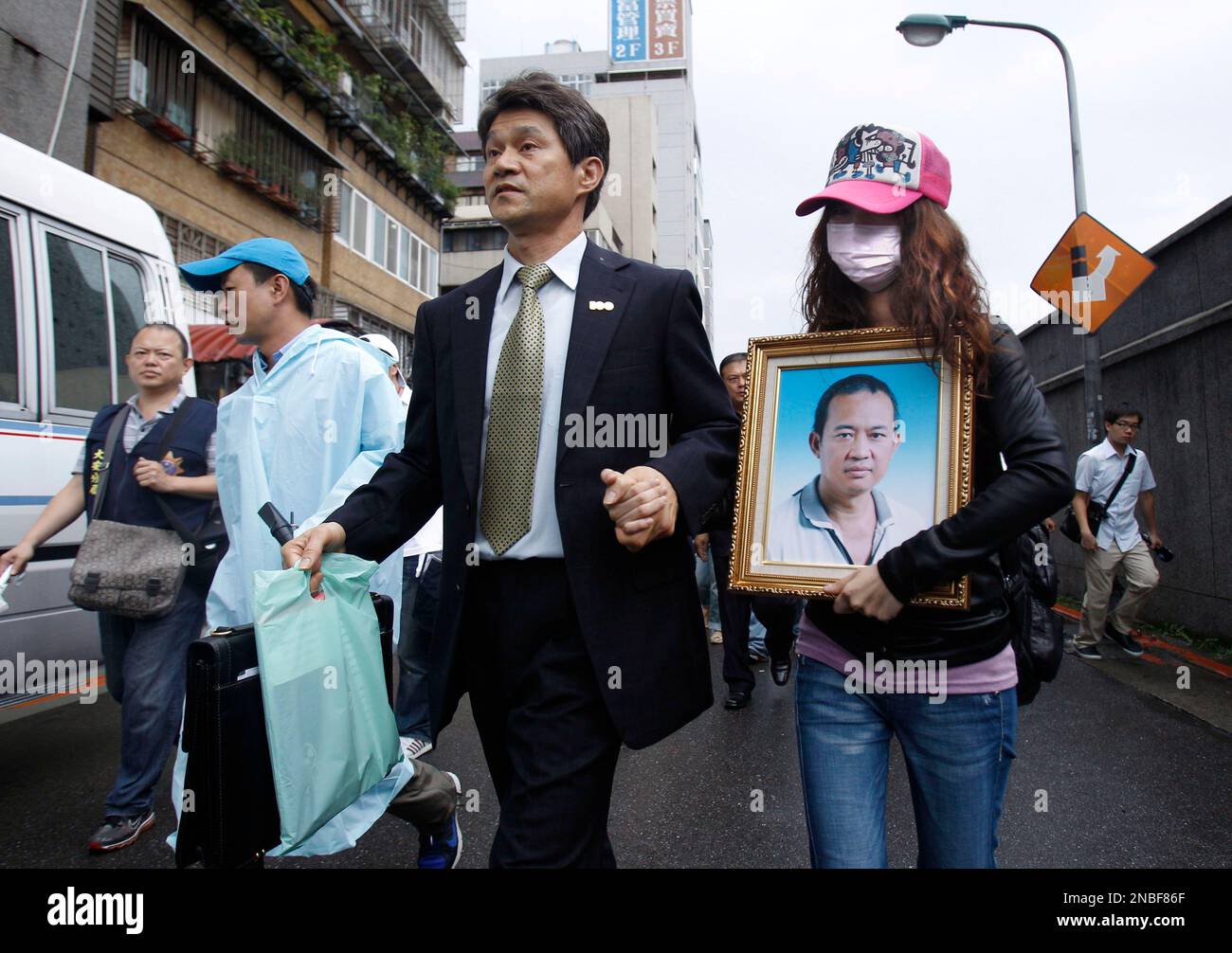 Daughter Wu Hui-hua carries a portrait of her father Wu Lai-yu who was ...