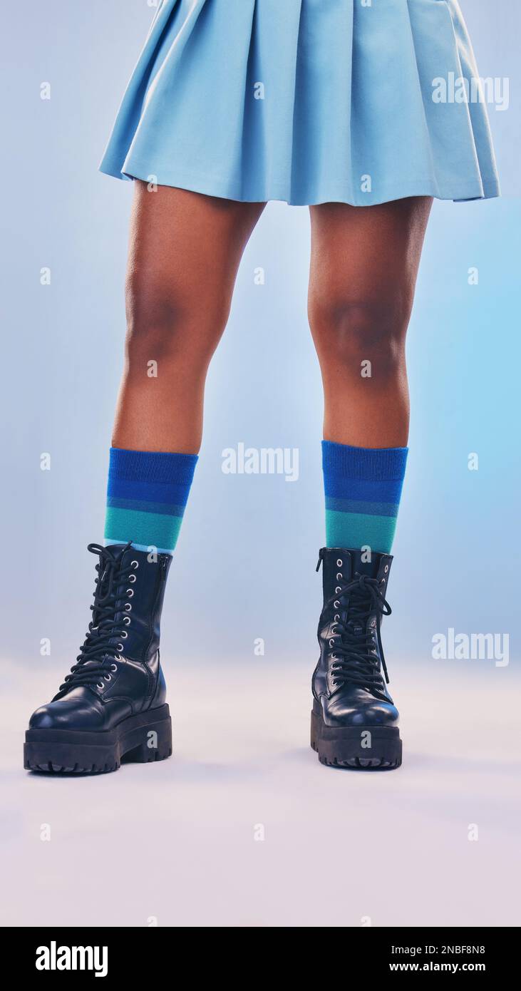 Boots, gen z fashion and legs of a young women in a studio with rock ...