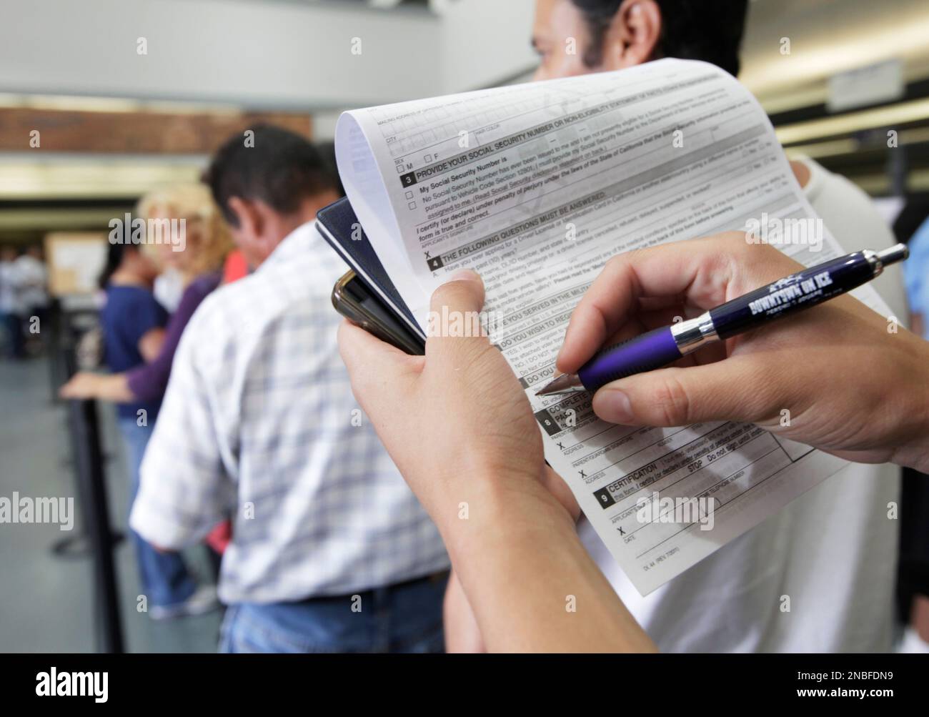 In this July 11, 2011 photo, people fill out forms in which they can ...