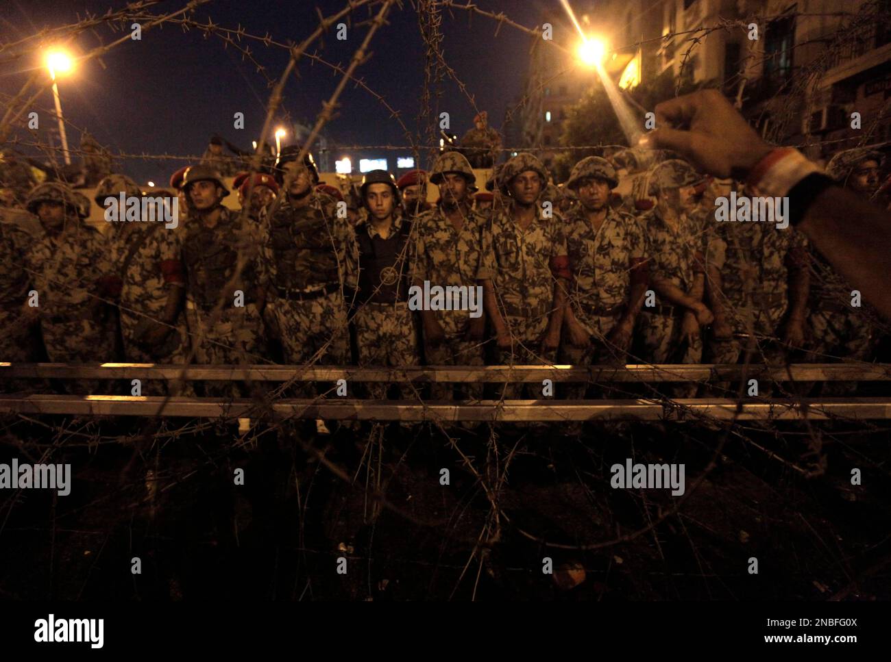 Egyptian army soldiers guard behind razor-wire as they block the way to ...