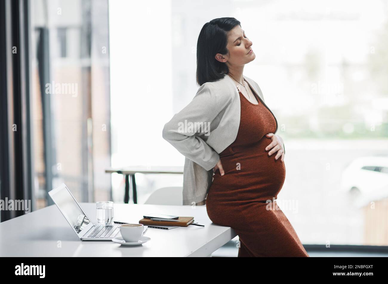 Being pregnant is no piece of cake. a pregnant young businesswoman ...