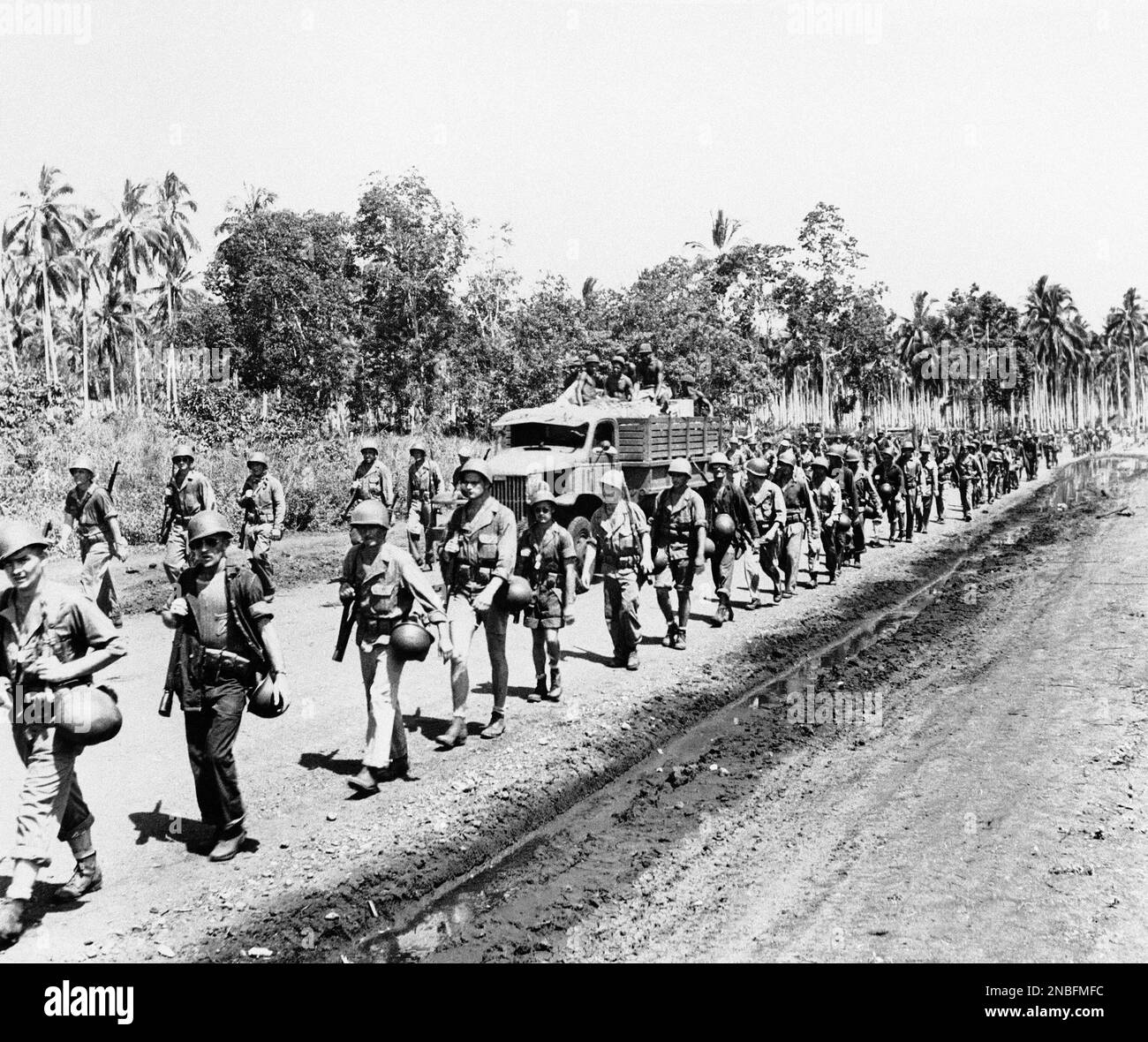 Troops of U.S. forces on Guadalcanal march over a newly scraped road to ...