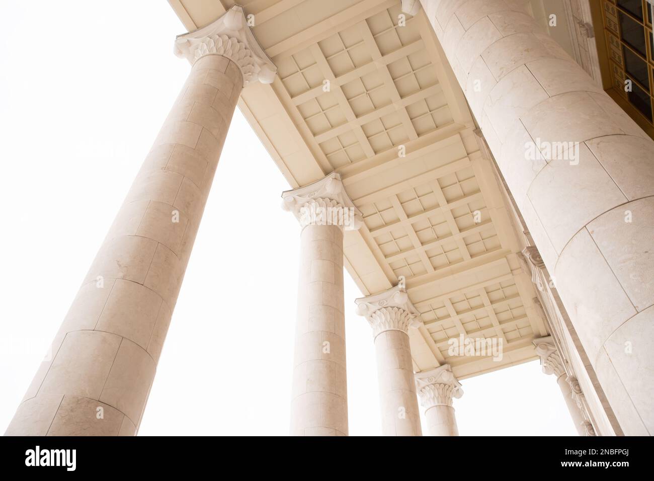 Tall columns on white rain clouds background, entrance to building ...
