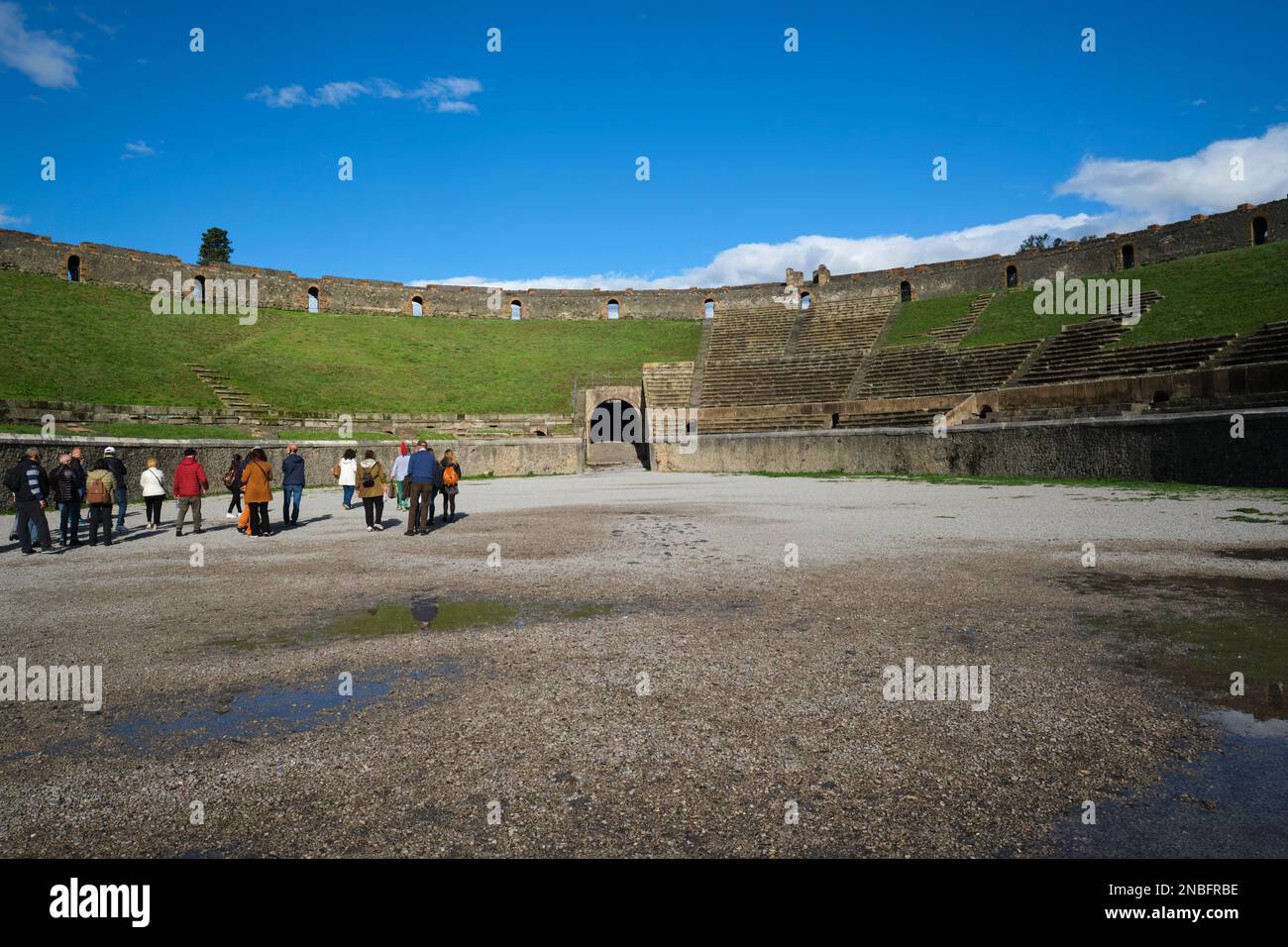 Tourists viewing the inside of the grass covered amphitheater. At ...