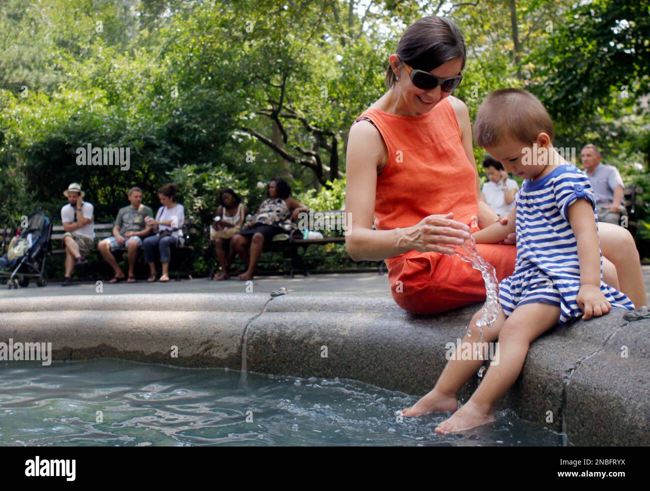 Andrea Abel splashes water on her daughter Maxine, 1, at a fountain in ...