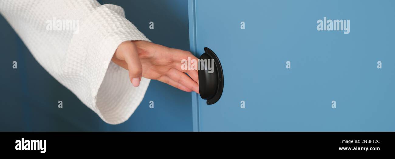 Woman hand opens blue closet door panel or modern closet door Stock ...