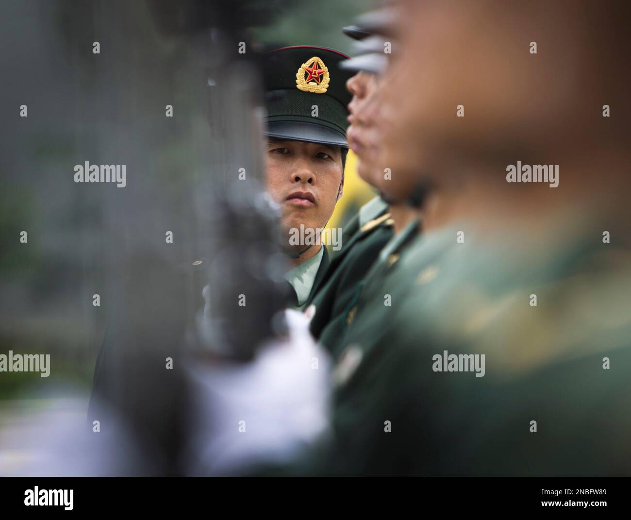 A military officer, center, checks a line of soldiers of the Chinese ...