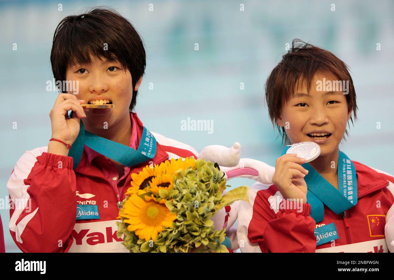China's Chen Ruolin, left, bites the gold medal of the women's 10m ...