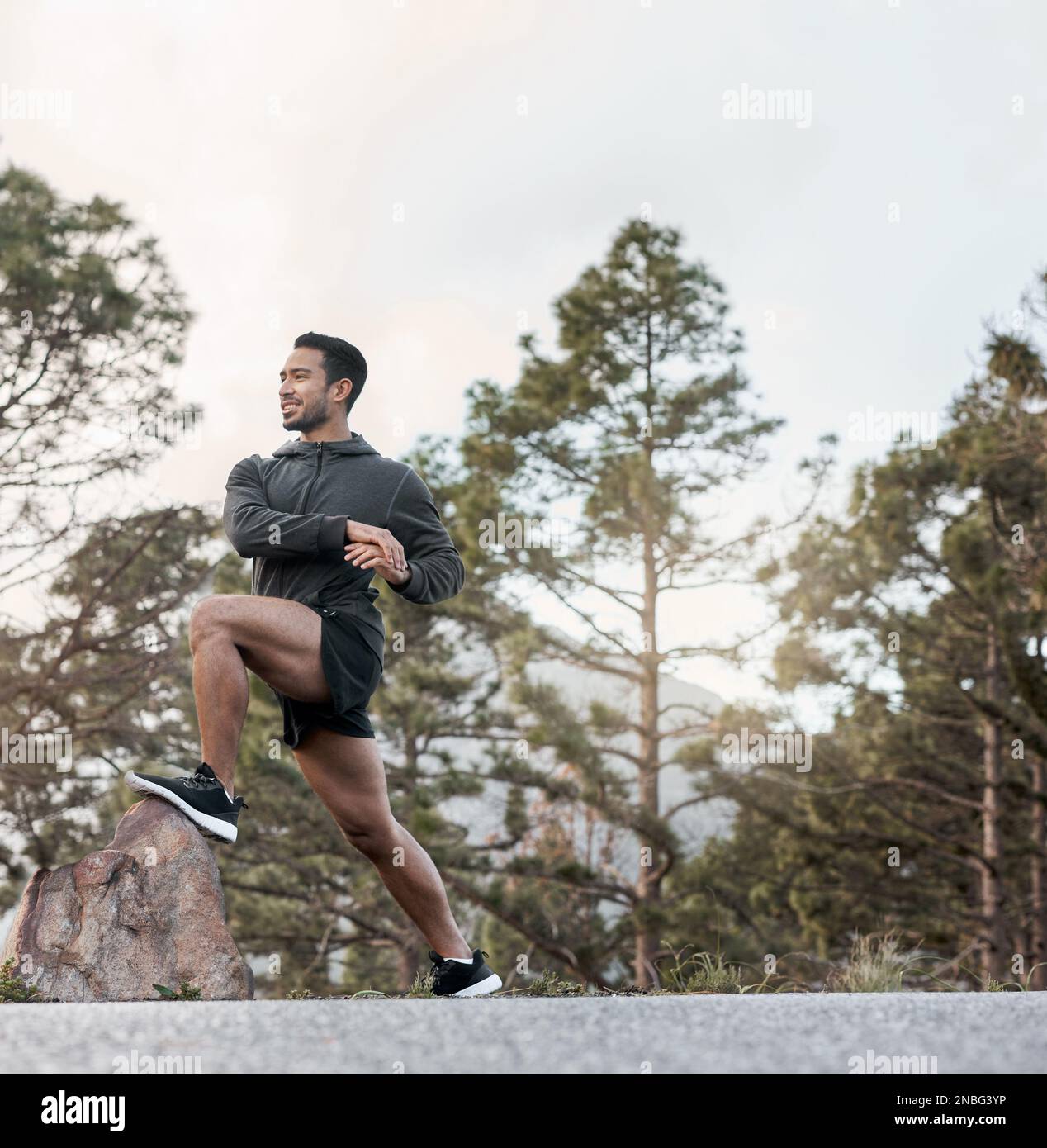 Prepping for his trail run. a sporty young man stretching his legs ...