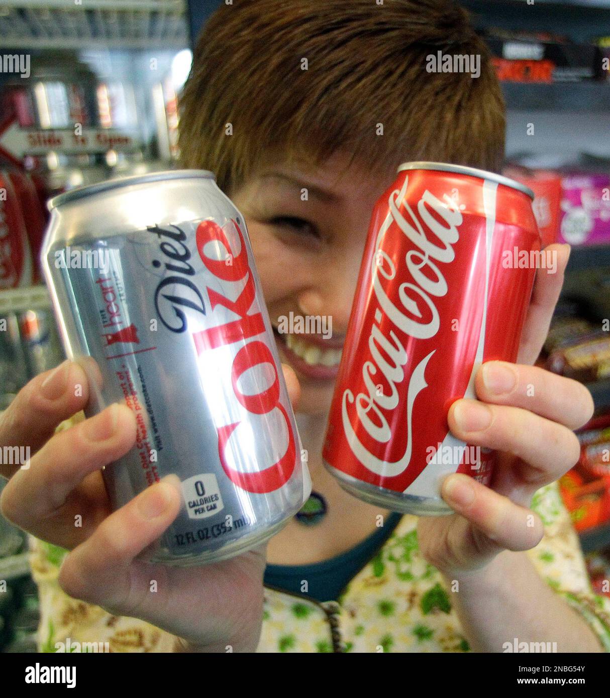 FILE - In this March 17, 2011 file photo, Jane Choi holds cans of Coca ...