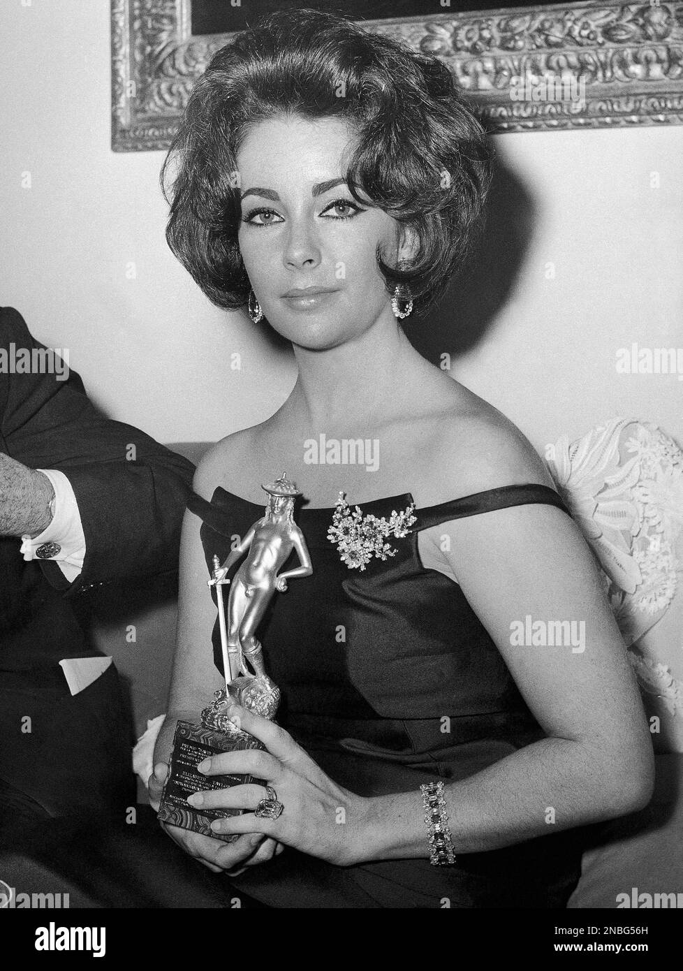 British-born Hollywood actress Elizabeth Taylor smiles holding the ...