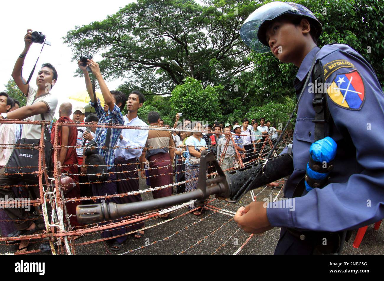 An armed Myanmar riot policeman stands guards behind barricades as ...