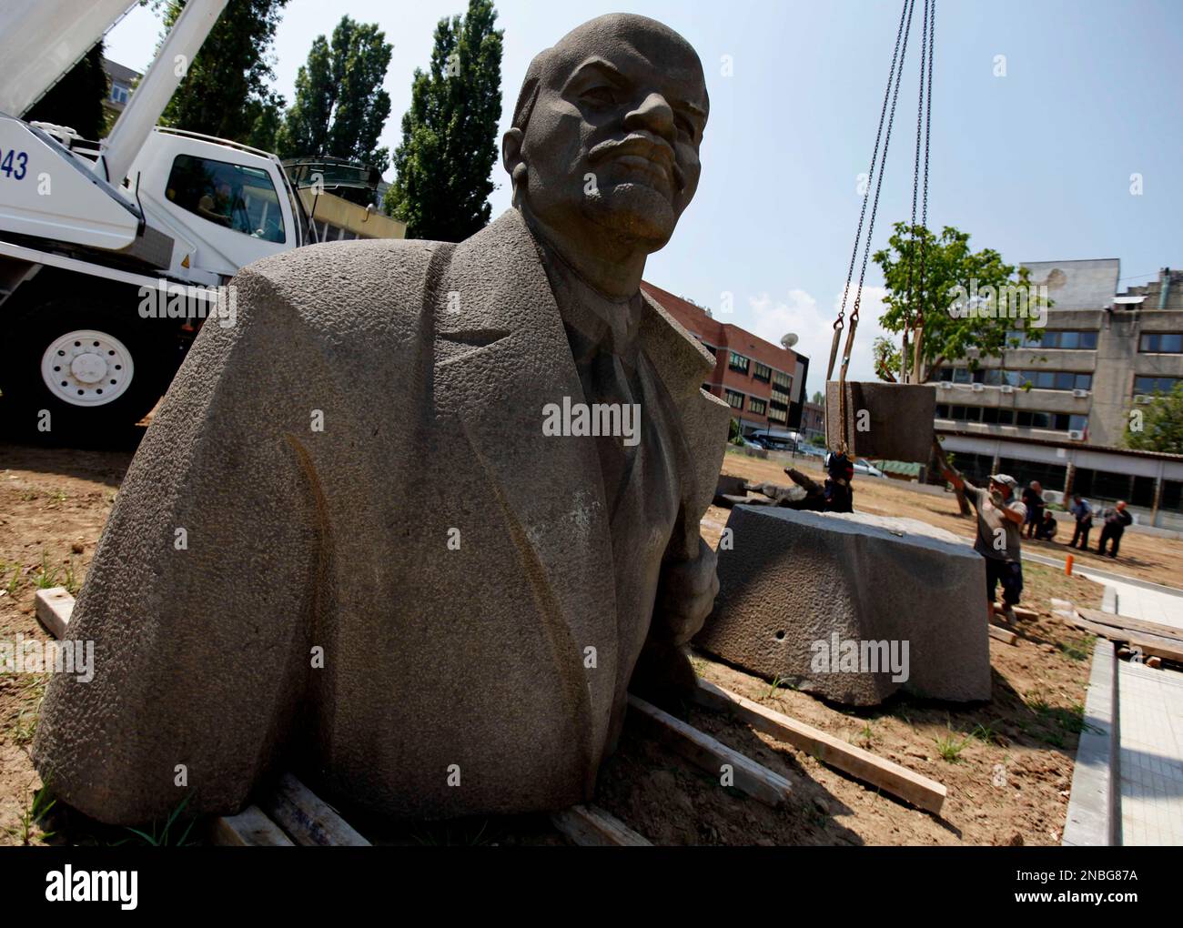 Workers monitor the lifting of parts of a 12-meter-high monument of the ...