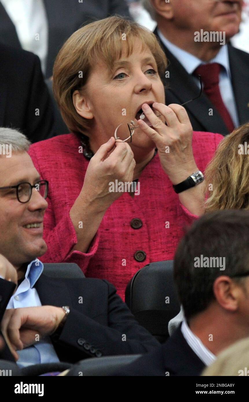 German Chancellor Angela Merkel cleans her glasses as she watches the ...