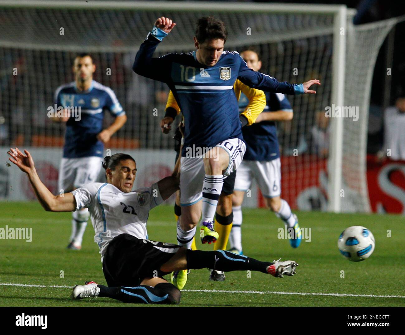 Argentina's Lionel Messi, right, is tackled by Uruguay's Martin Caceres ...