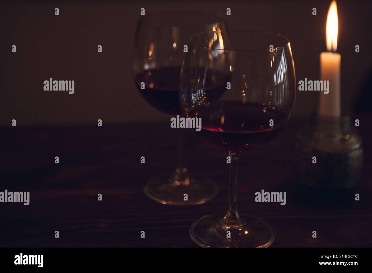 Romantic date. Red wine in focus on foreground Stock Photo - Alamy