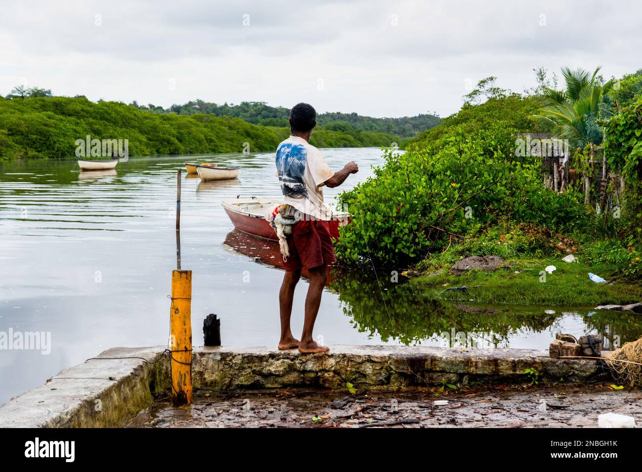 A Fisherman throwing bait to catch fish on the edge of the Jaguaripe ...