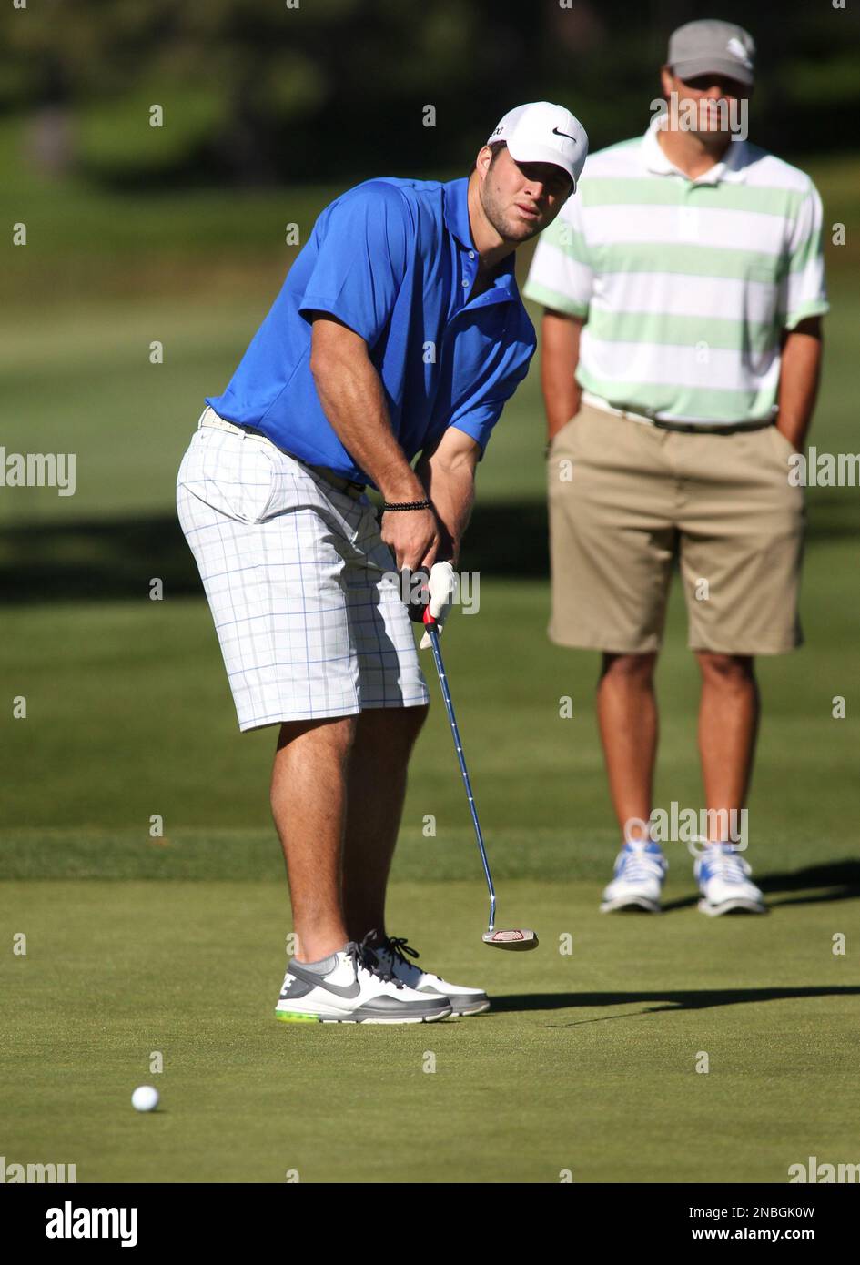 Denver Broncos quarterback Tim Tebow putts during a practice round for ...