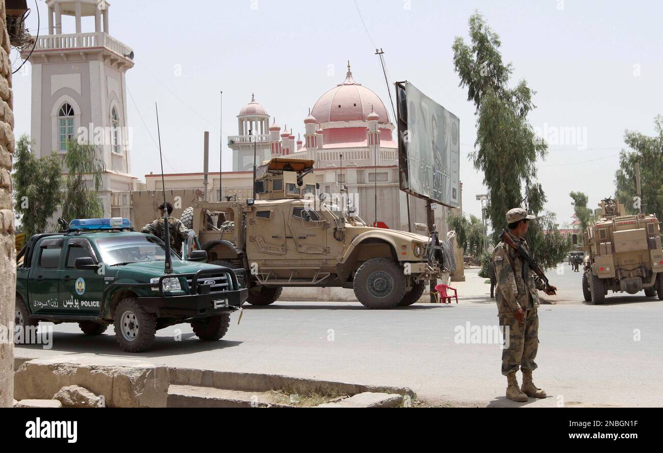 Afghan and U.S forces stand outside the mosque after a suicide attack ...