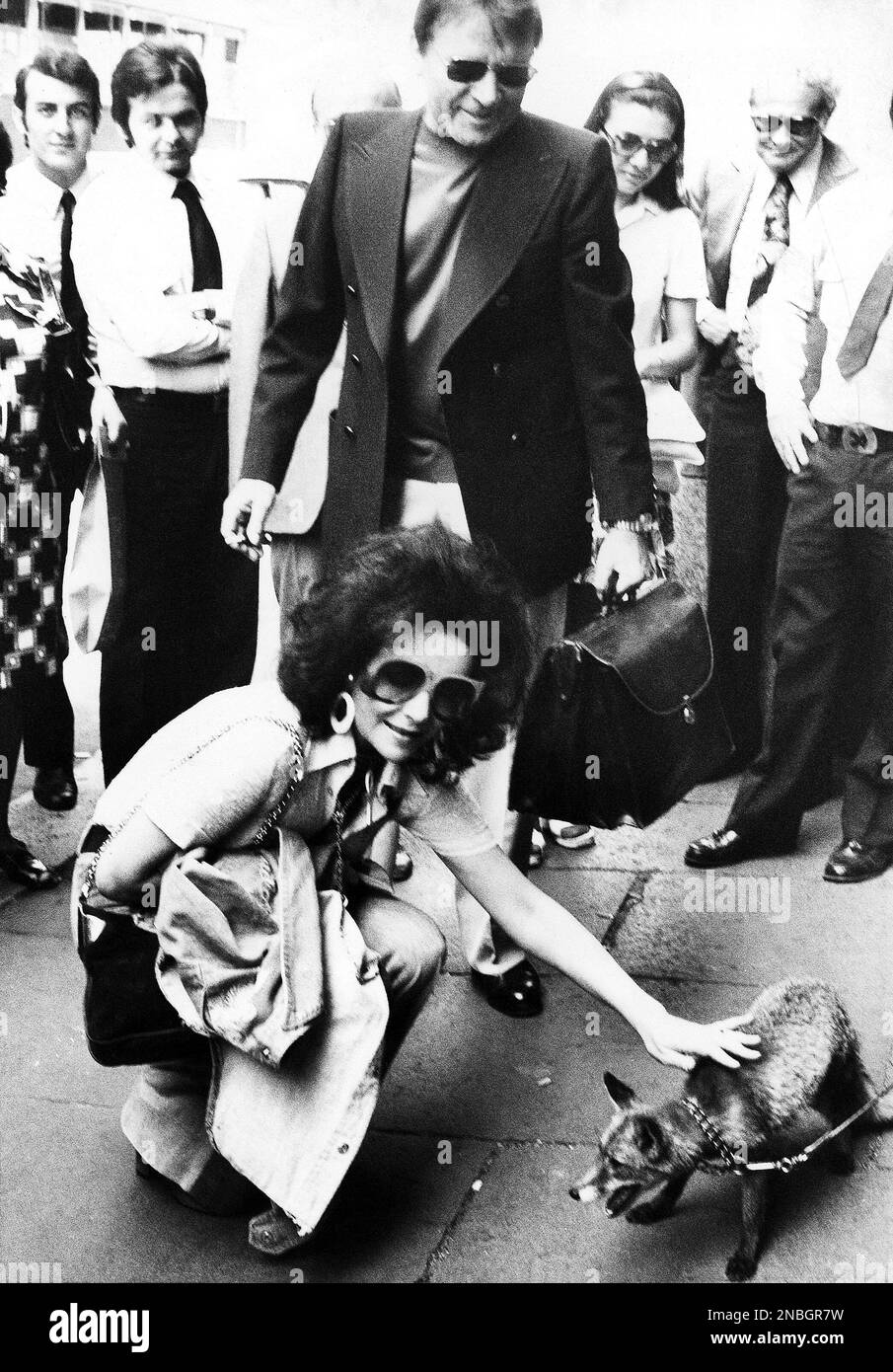 British actress Elizabeth Taylor is watched by her smiling husband ...