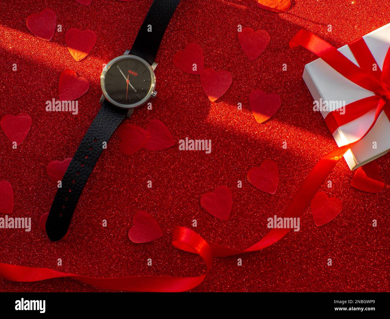 Hugo by Hugo Boss. Gift box and black watch is on red heart paper ...