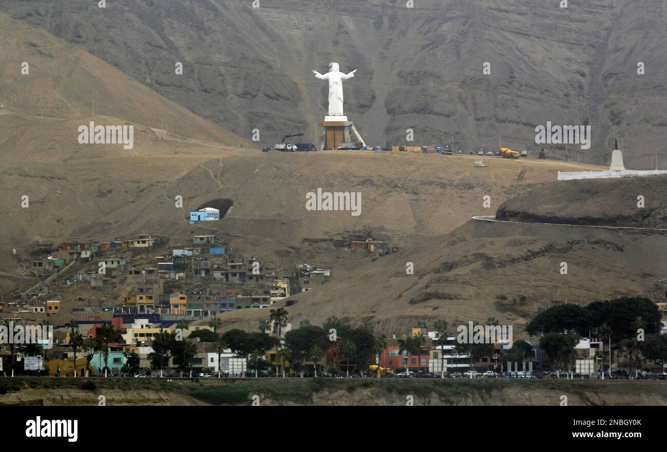 In this photo taken June 23, 2011, a statue of Jesus stands above homes ...