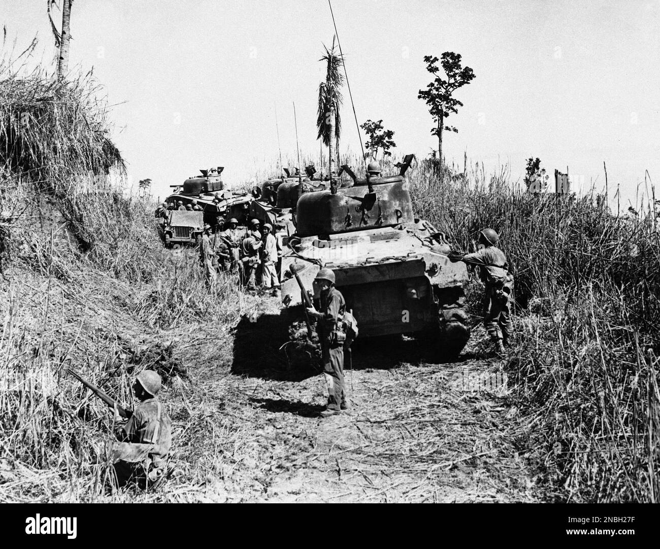A group of American tanks pause behind a hill before moving up to the ...