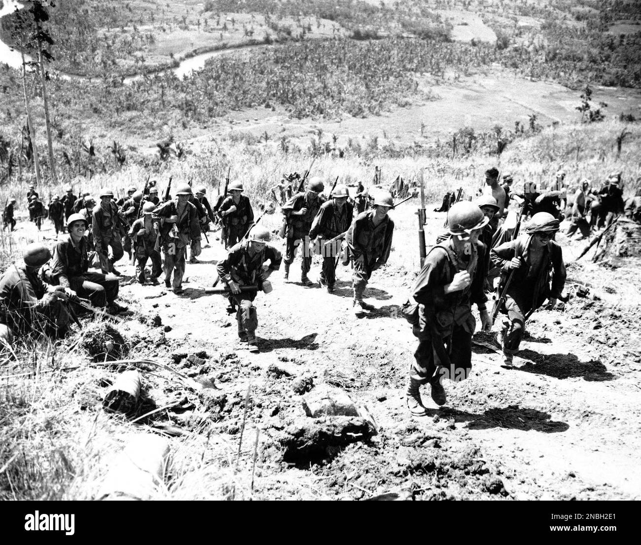 Advancing up a steep hill on Leyte island, troops of the U.S. 96th Division head into the attack ...