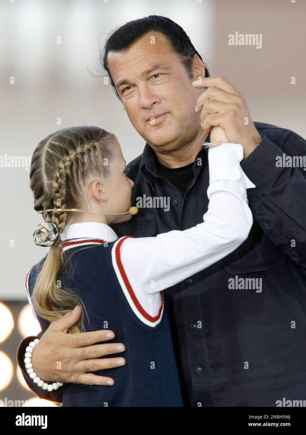 American actor Steven Seagal dances with an young girl at a charity ...