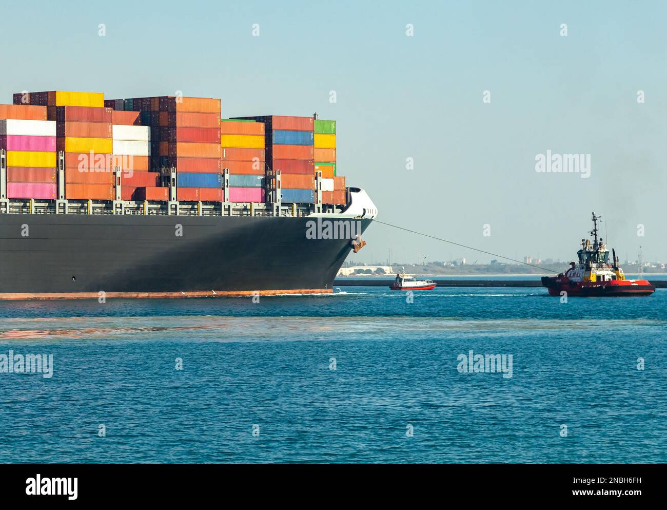 Large cargo container ship loaded with containers against the blue sky ...