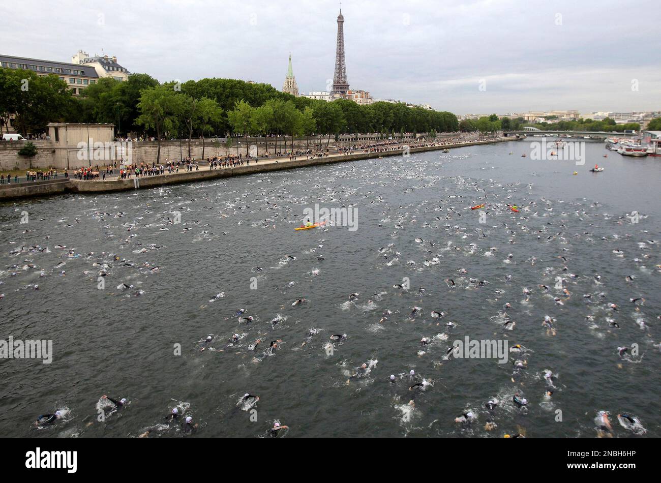Competitors swim in the Seine River during the Paris Triathlon ...
