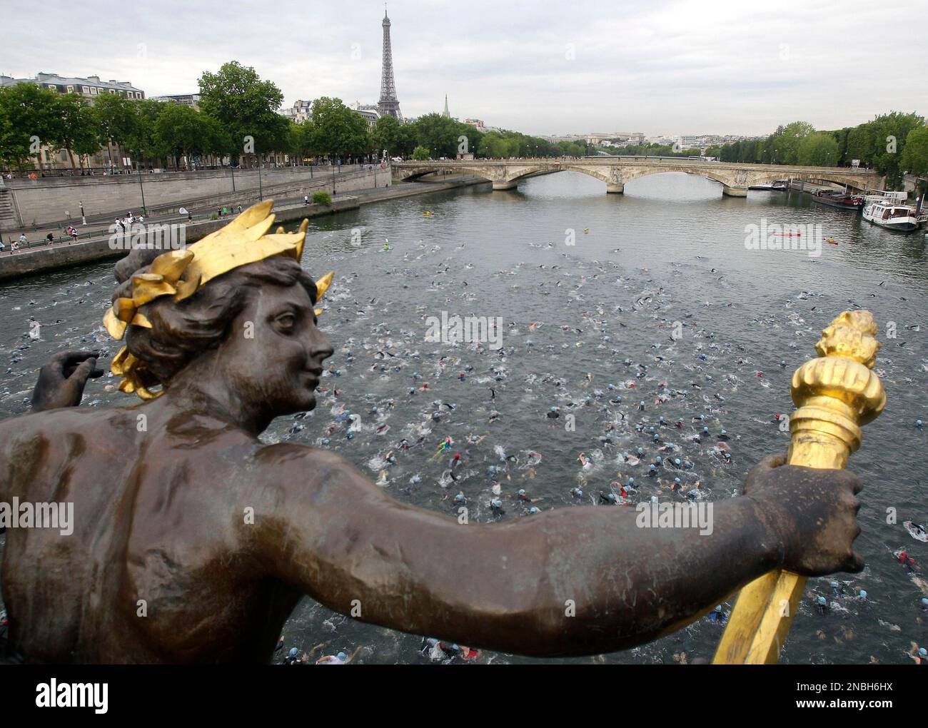 Competitors swim in the Seine River during the Paris Triathlon ...