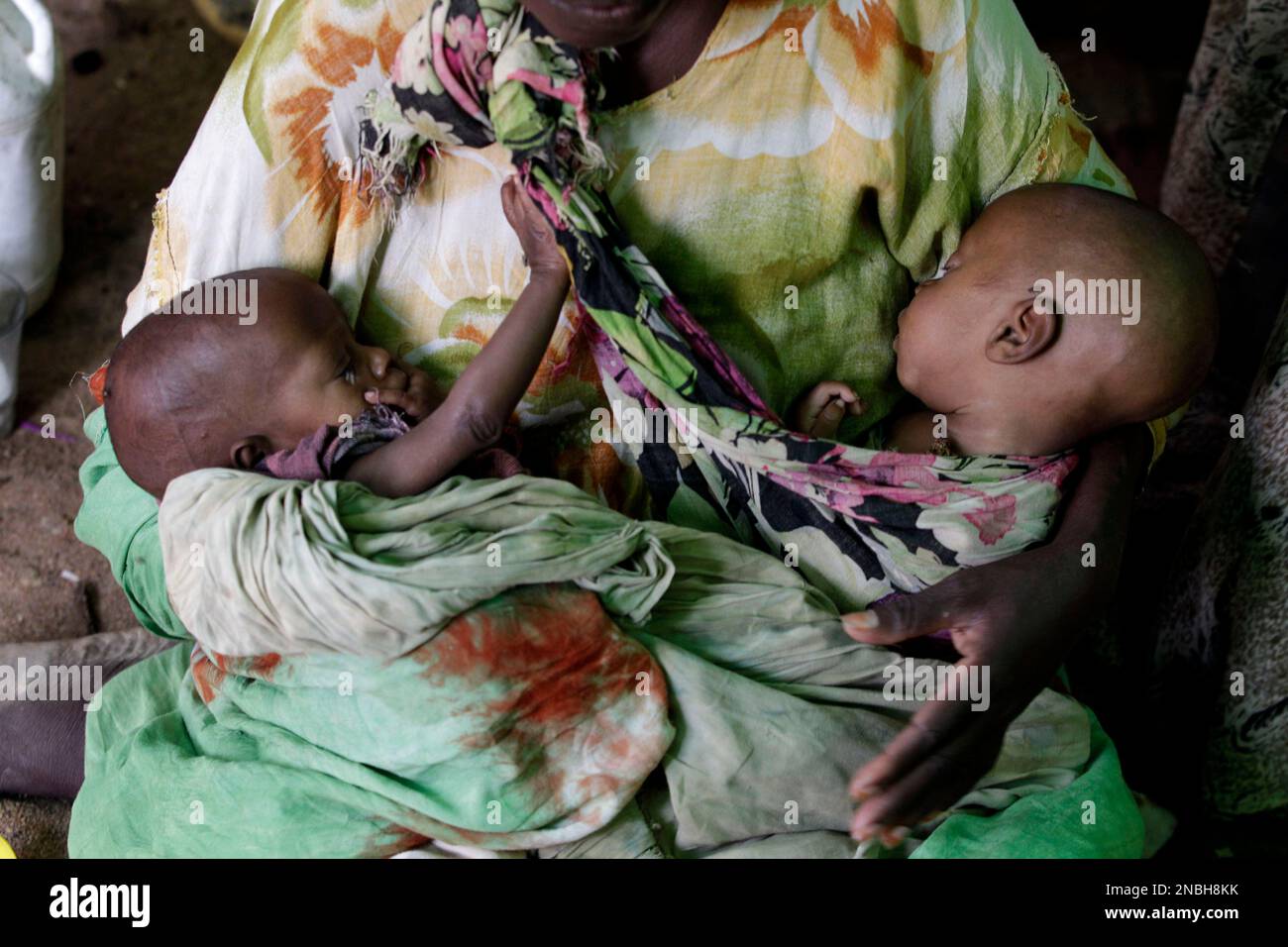 A Somali refugee cradles her one-month old twins, born at the camp ...