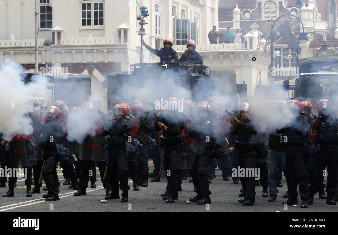 Malaysian riot police officers fire tear gas at protesters during a ...
