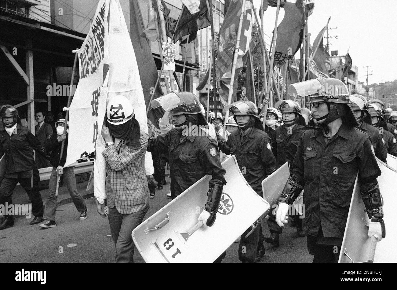 Flag-carrying student demonstrators are surrounded by riot police as ...