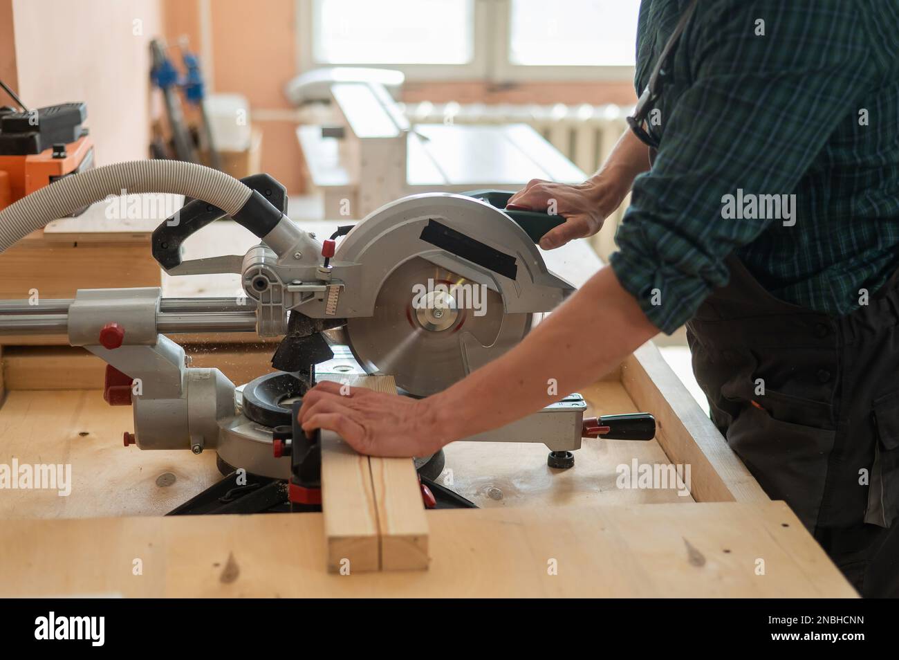 Master cuts the board with a circular saw in the workshop Stock Photo ...